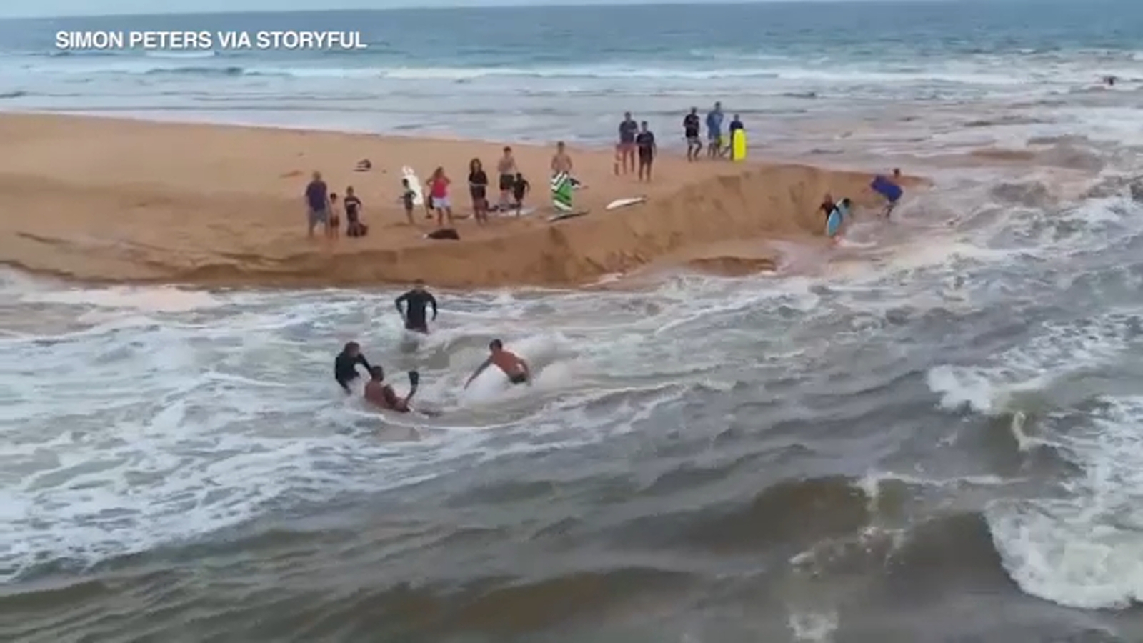Drone video shows surfers rescue elderly man swept away by heavy ...
