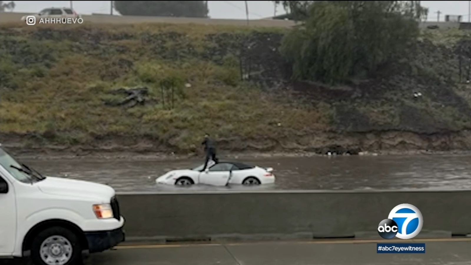 Caught on video: Porsche driver stranded on top of car on flooded 5 ...