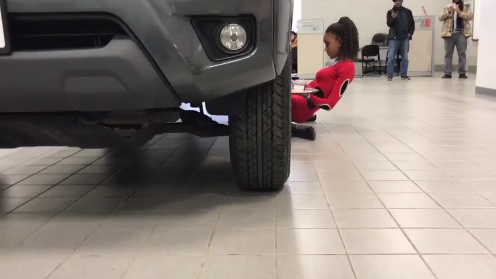 Woman limbos under SUV holding two trays of drinks - ABC13 Houston