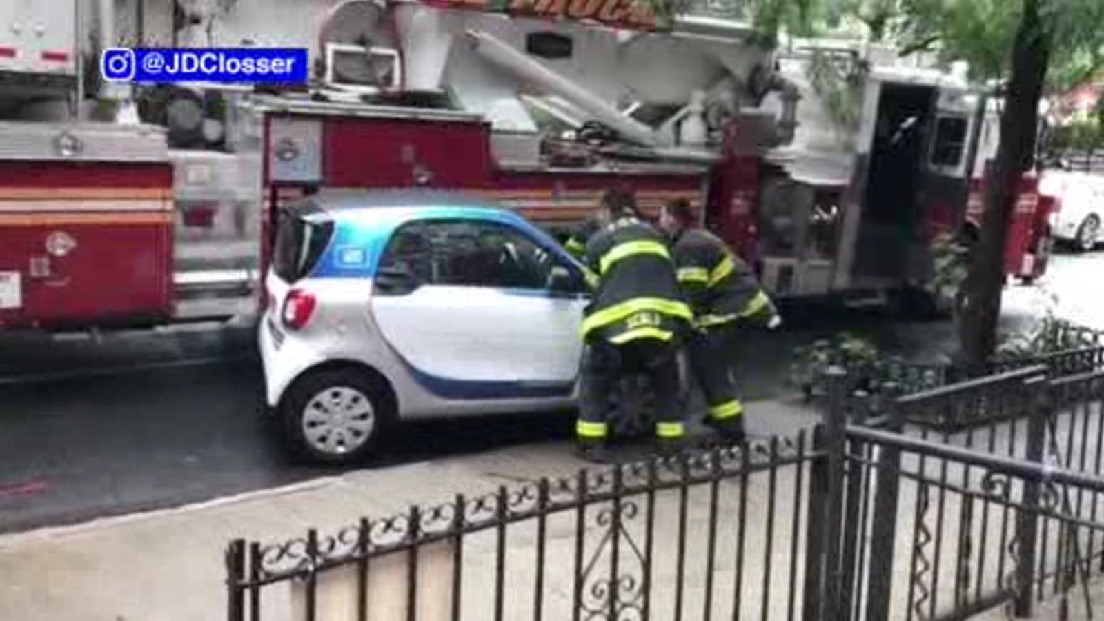Firefighters work together to move small car out of the way of their ...
