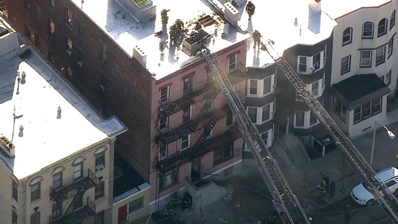 Firefighters rescue people trapped on fire escape of burning building ...