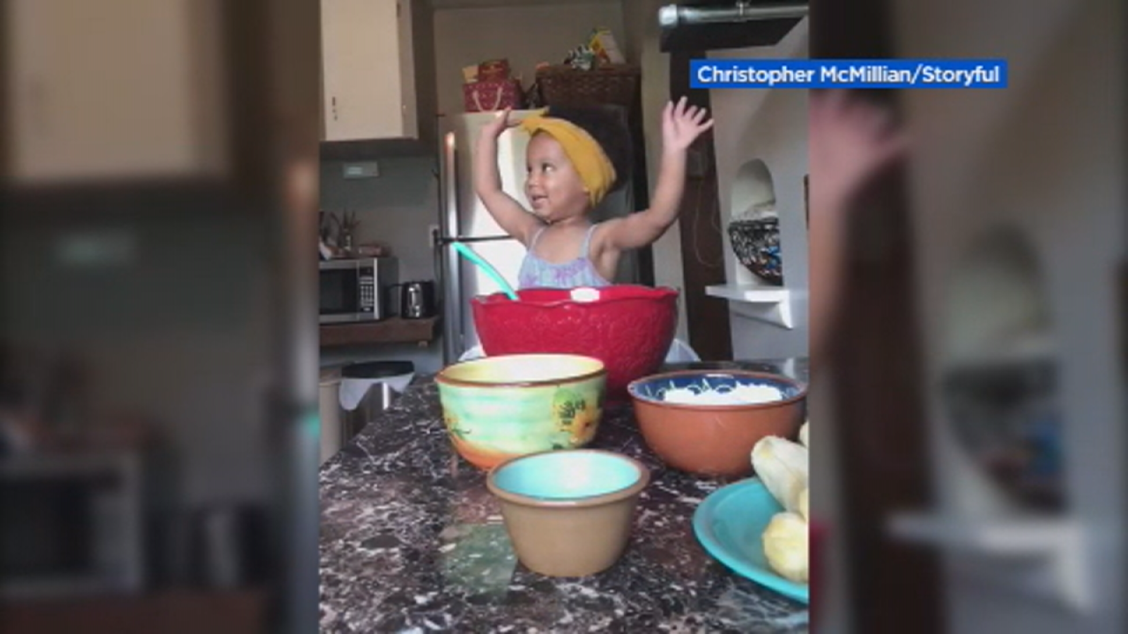 Little girl raises arms in worship before baking banana bread with mom ...